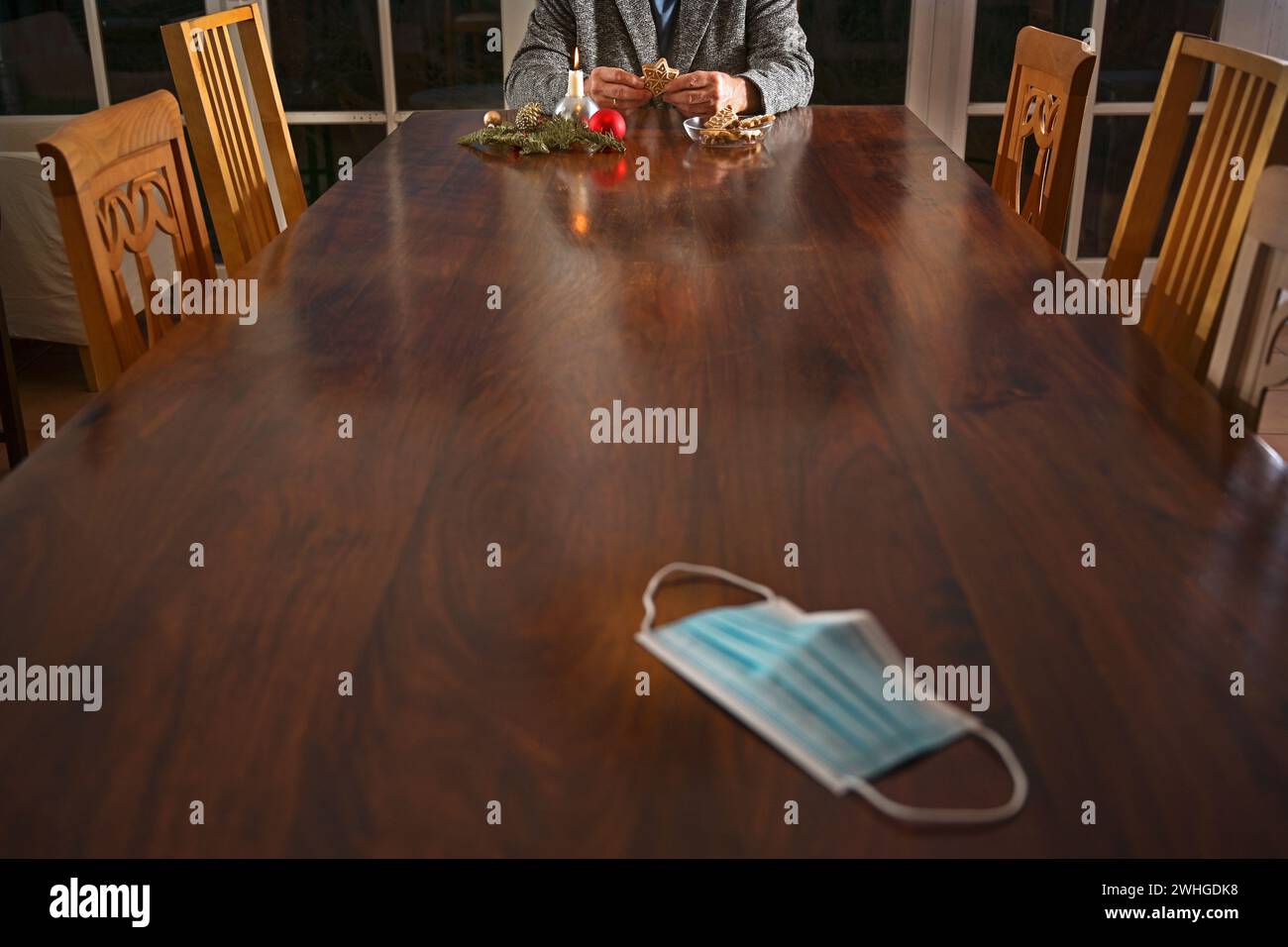 Single man at the end of a family table with poor Christmas decoration ...