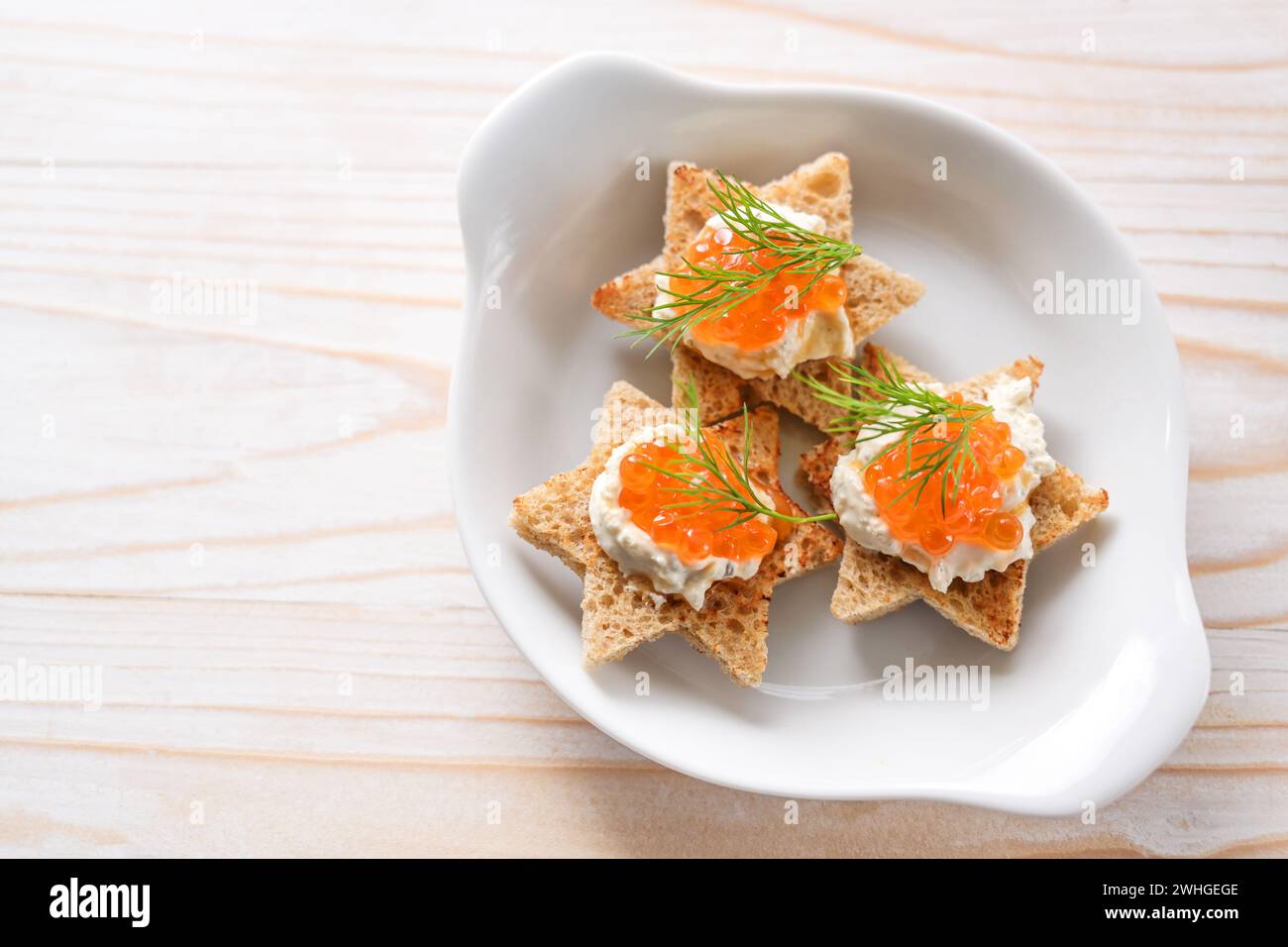 Canapes with red caviar on toasted bread in star shape with cream and ...