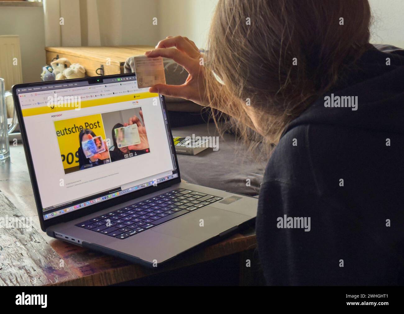 Woman is identifying herself in a PostIdent procedure on a laptop in ...