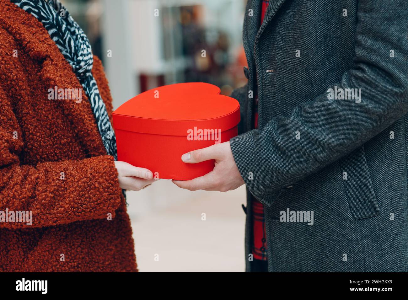 A guy give his girlfriend a heart-shaped box in Valentine's Day. Young ...