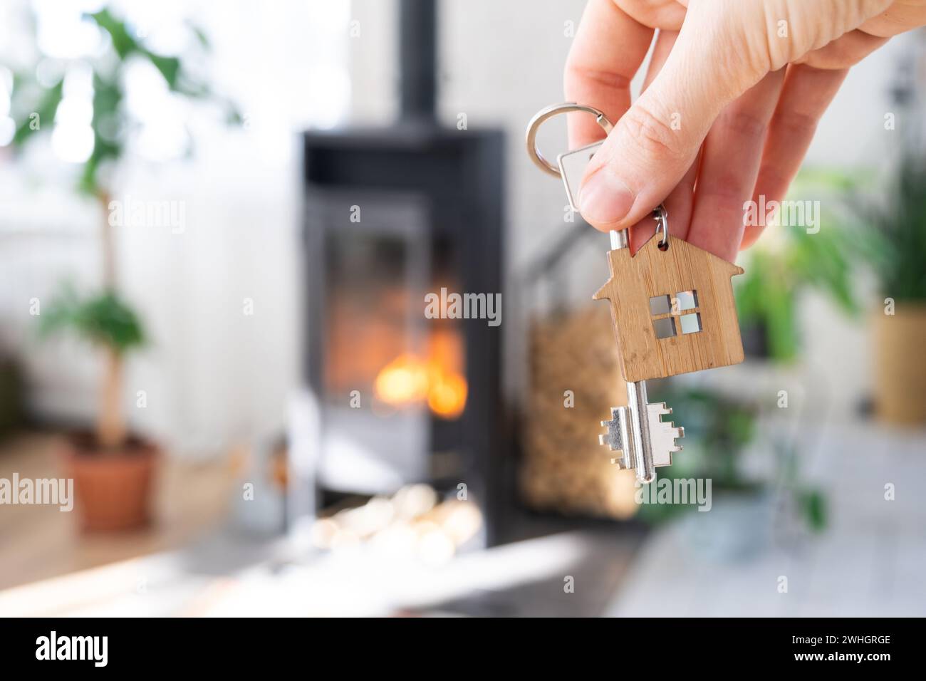 Key to house with keychain against background of fireplace stove with ...