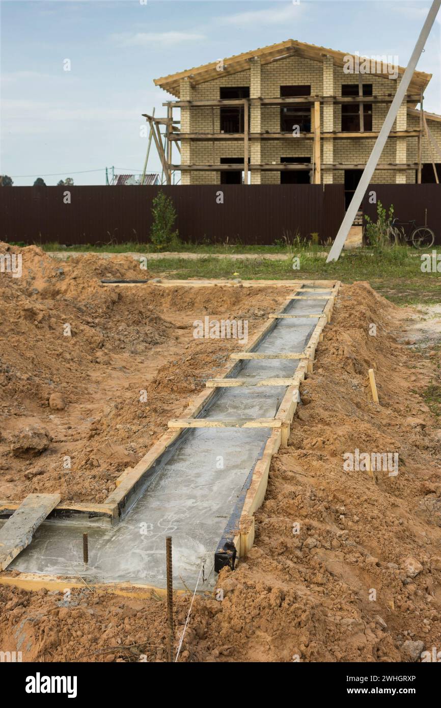 Formwork of the foundation of the future house is filled with concrete ...
