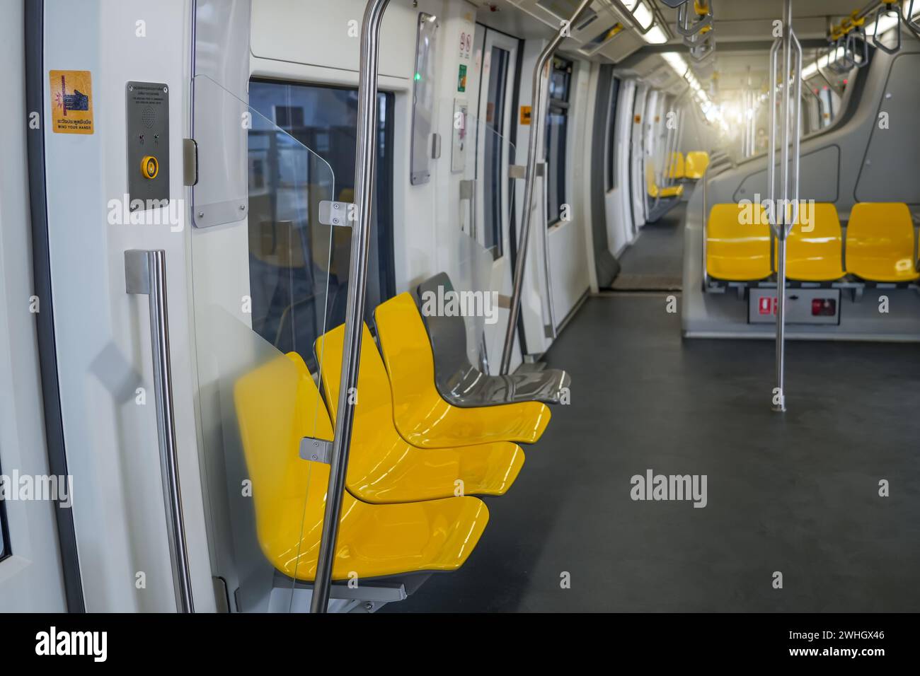 Interior of a passenger car of a commuter train. Yellow plastic seats ...