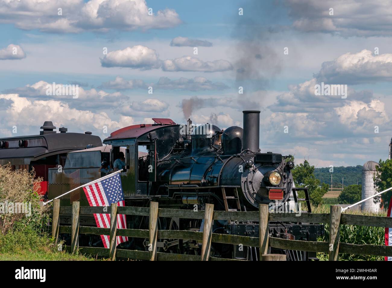 Restored Antique Steam Passenger Train Approaches a Fence With Gently ...
