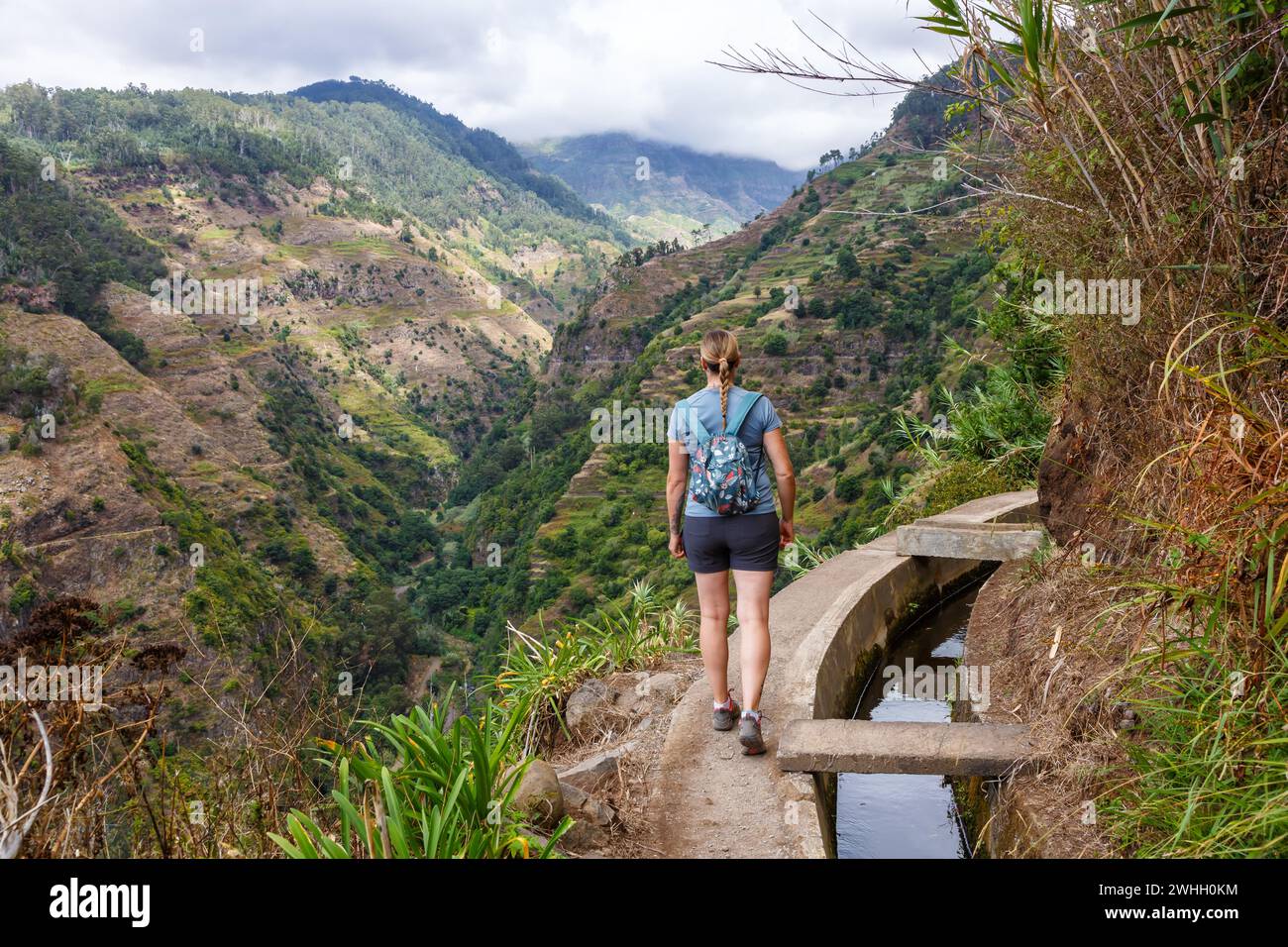 Young woman hiking along the Levada Nova hiking trail on Madeira Island ...