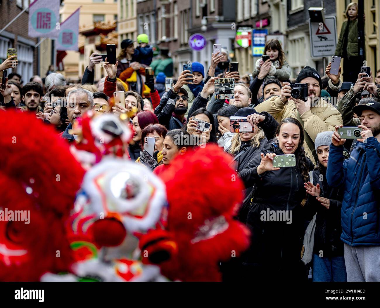 AMSTERDAM - Spectators during a traditional parade of lions and dragons ...