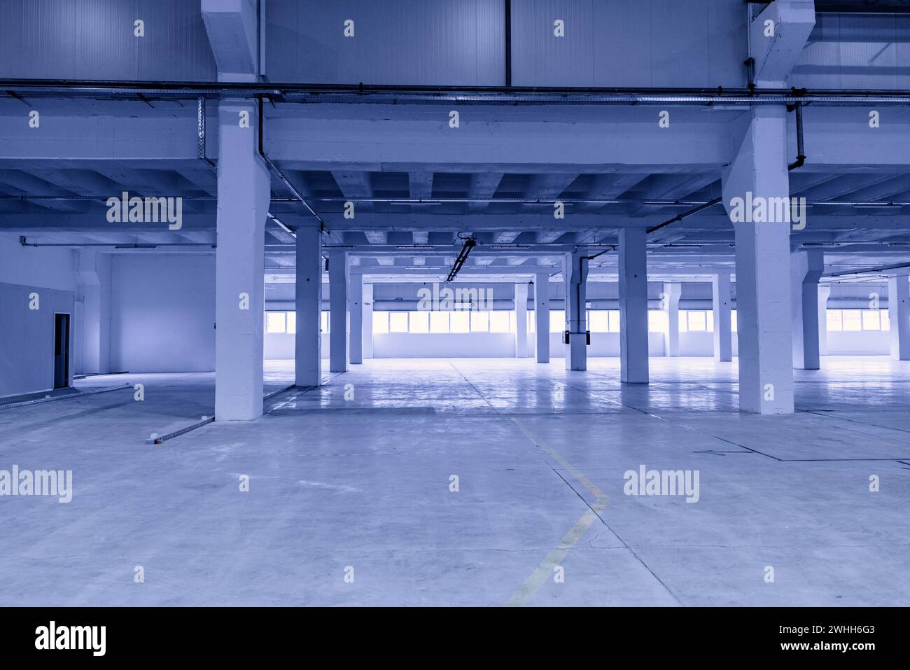 Inside of an empty factory builtding with windows Stock Photo - Alamy