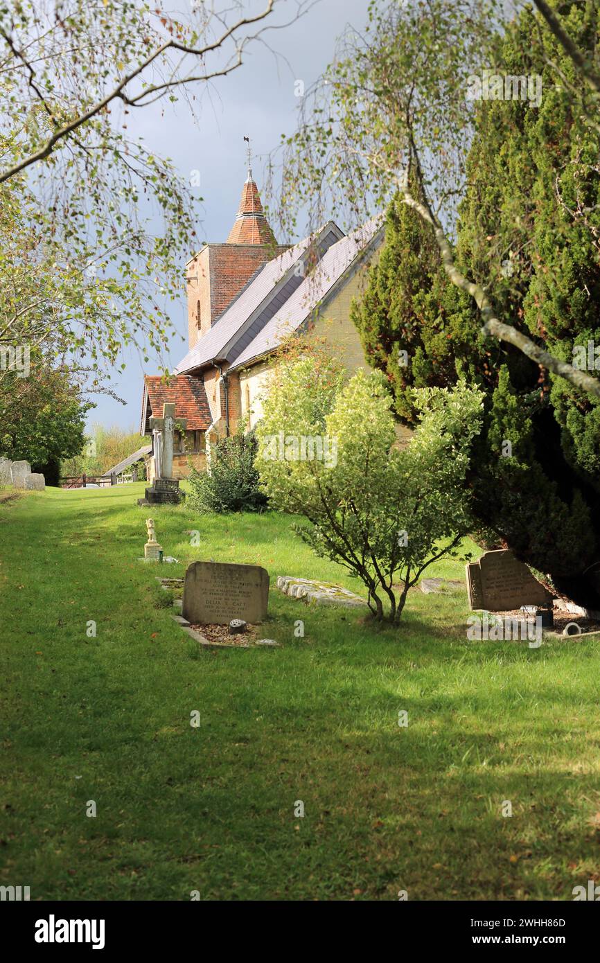 View through trees in churchyard to All Saints Church, Tudeley ...