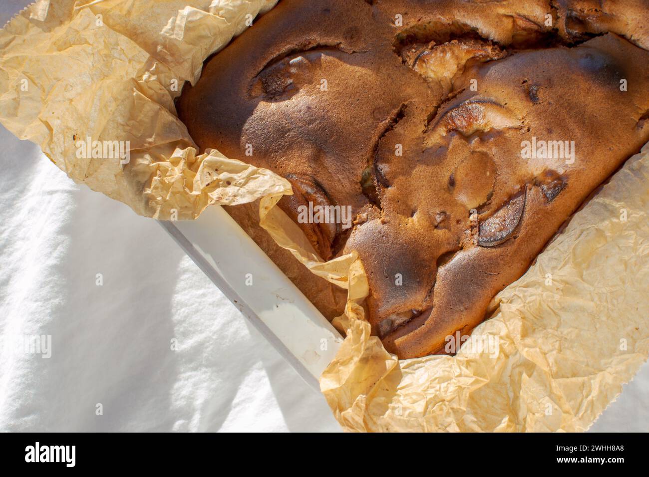 Freshly baked apple pie in a white mold on a white cotton base Stock ...