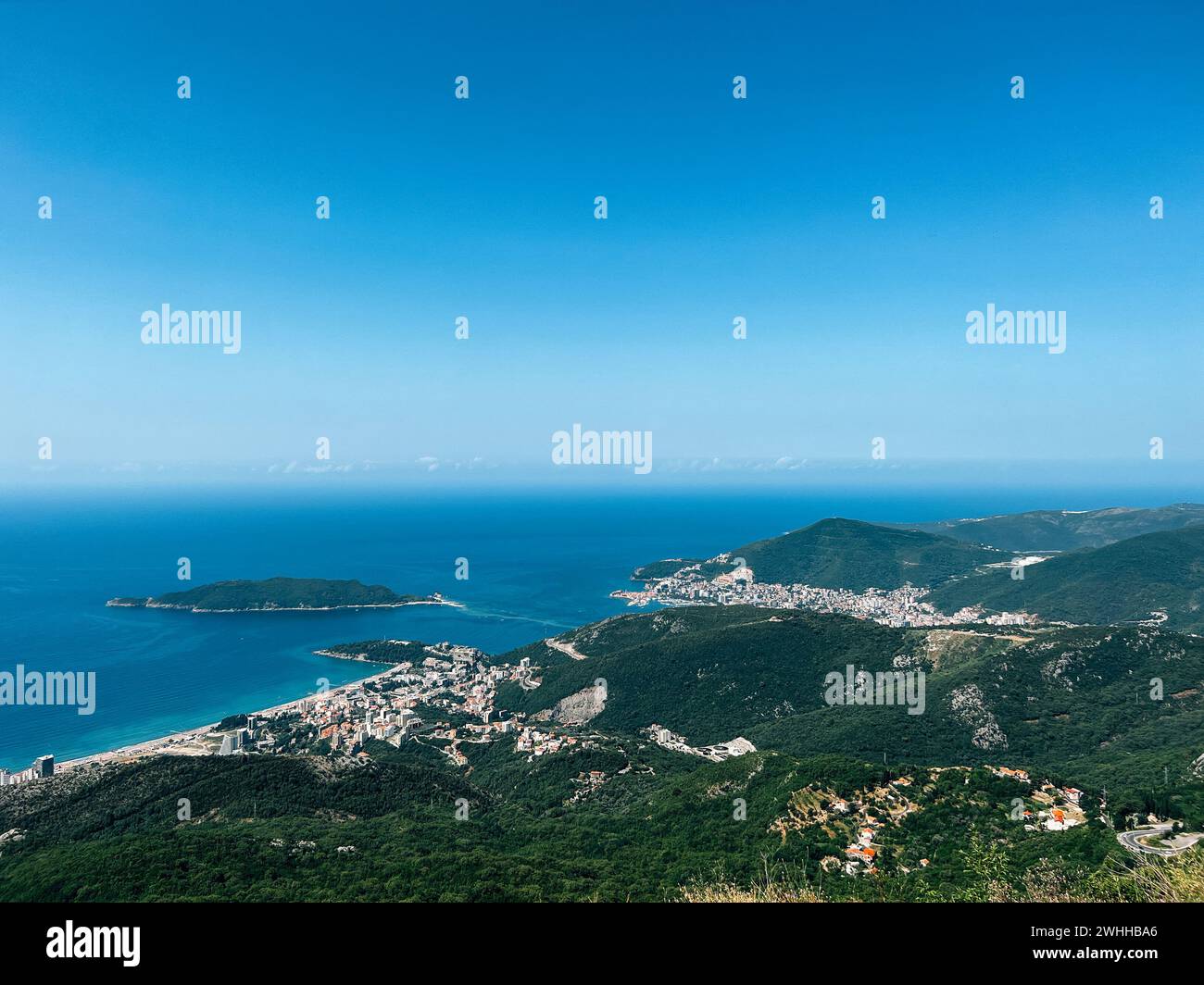 Mountain range near the blue sea merging with the clear sky Stock Photo ...