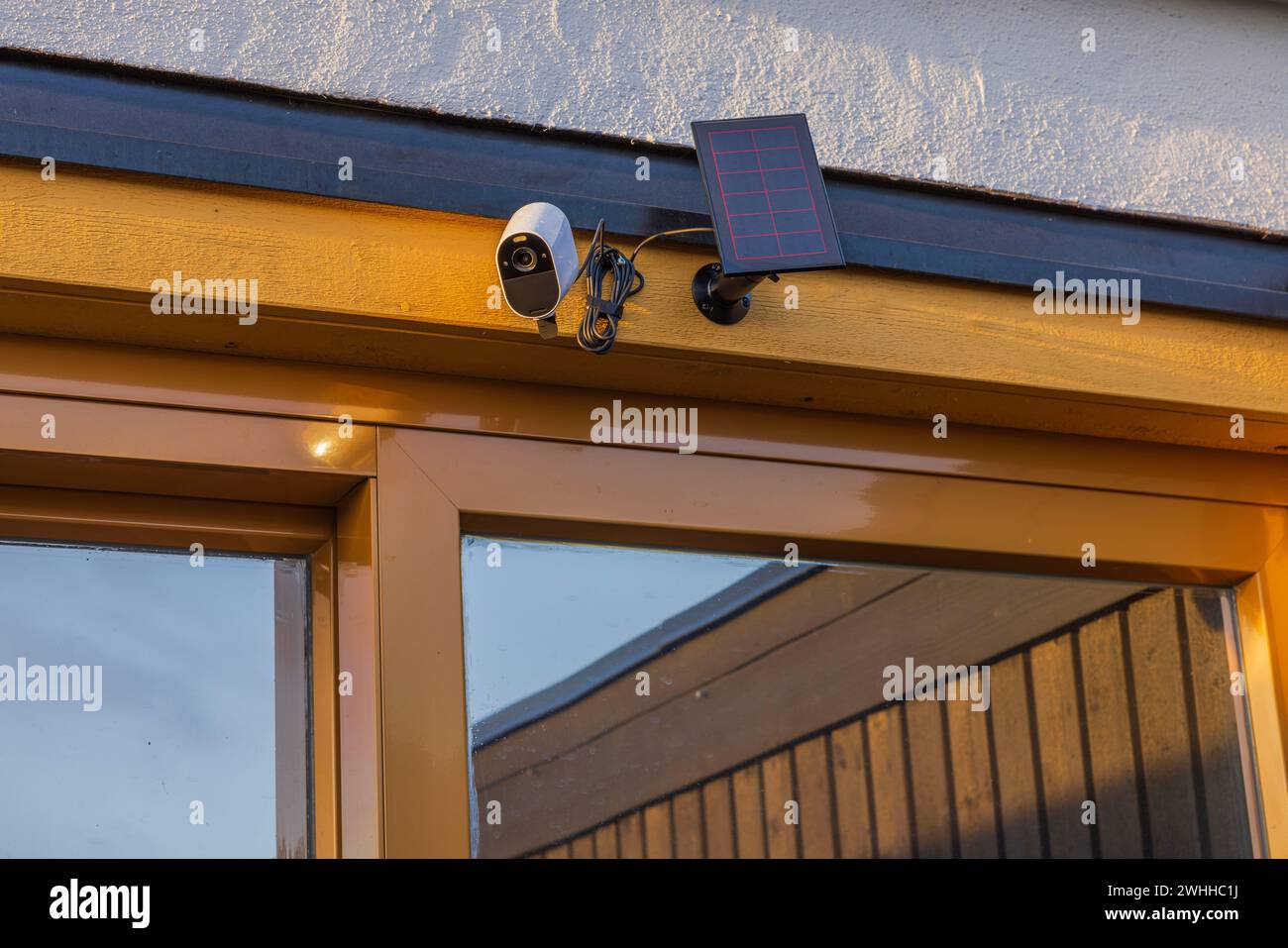 Close-up view of outdoor camera surveillance with solar panel on facade ...