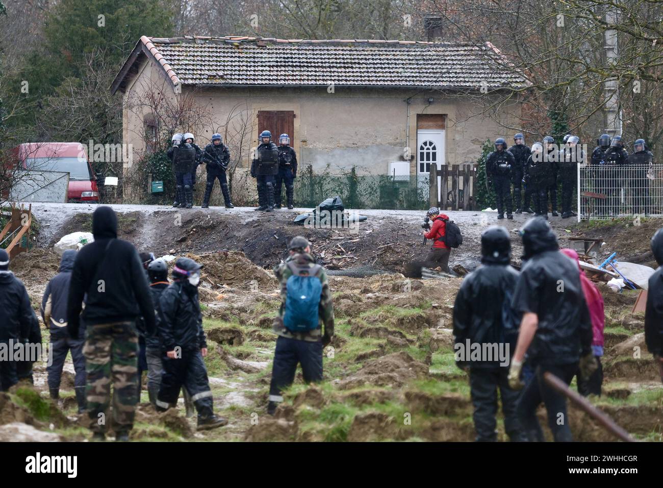 Environmental activists face riot police officers during a ...