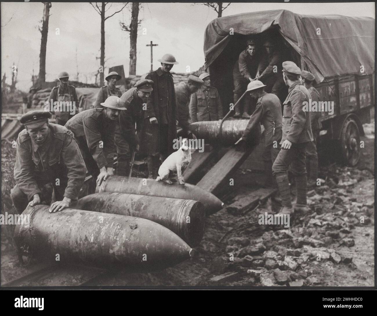 WWI Belgium: Soldiers nloading 15 inch Howitzer shells. A dog stands on ...