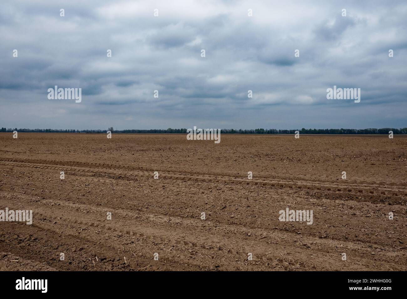 A barren landscape of ploughed earth under cloud cover Stock Photo - Alamy