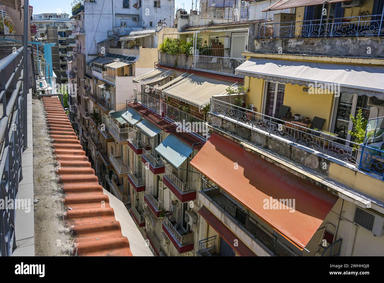 Narrow urban residential street with many balconies with different ...