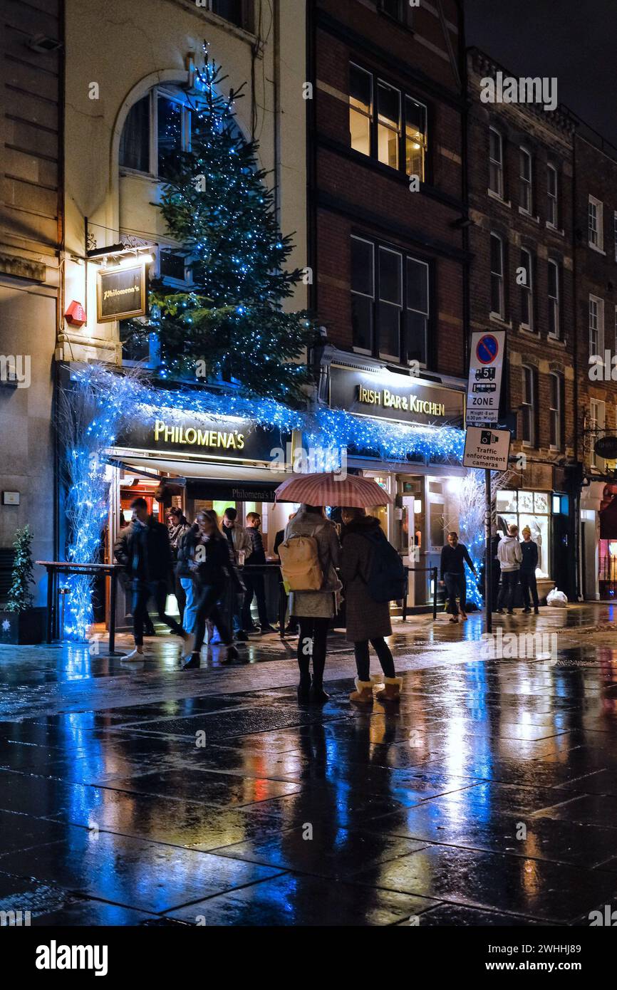 Christmas in Covent Garden. A couple under an umbrella in the rain ...