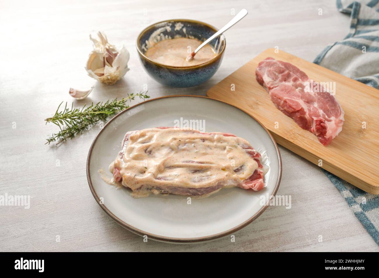 Raw pork steak is coated with a yogurt marinade with ingredients like ...