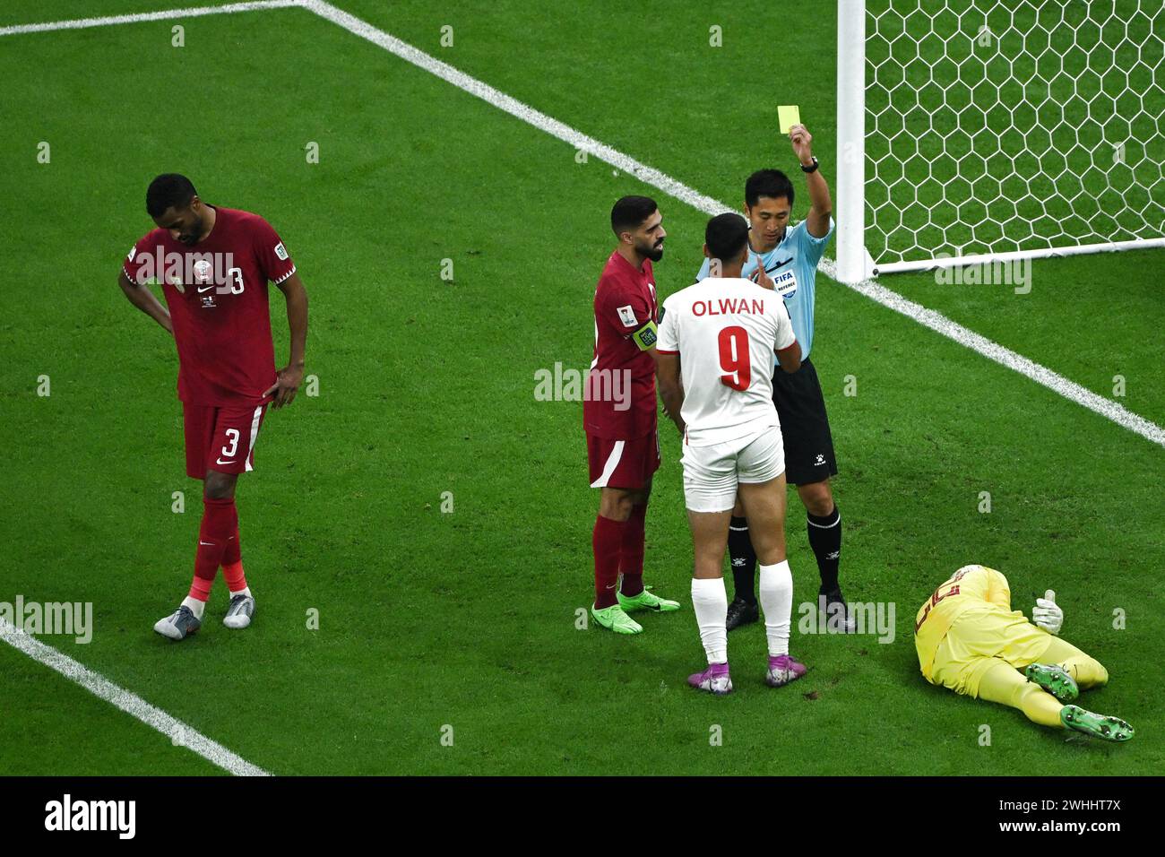 Lusail. 10th Feb, 2024. Referee Ma Ning (2nd R) shows yellow card to ...