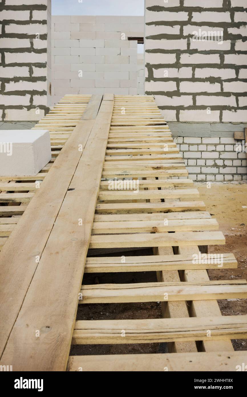 Enter a wooden gangway intol building under construction Stock Photo ...