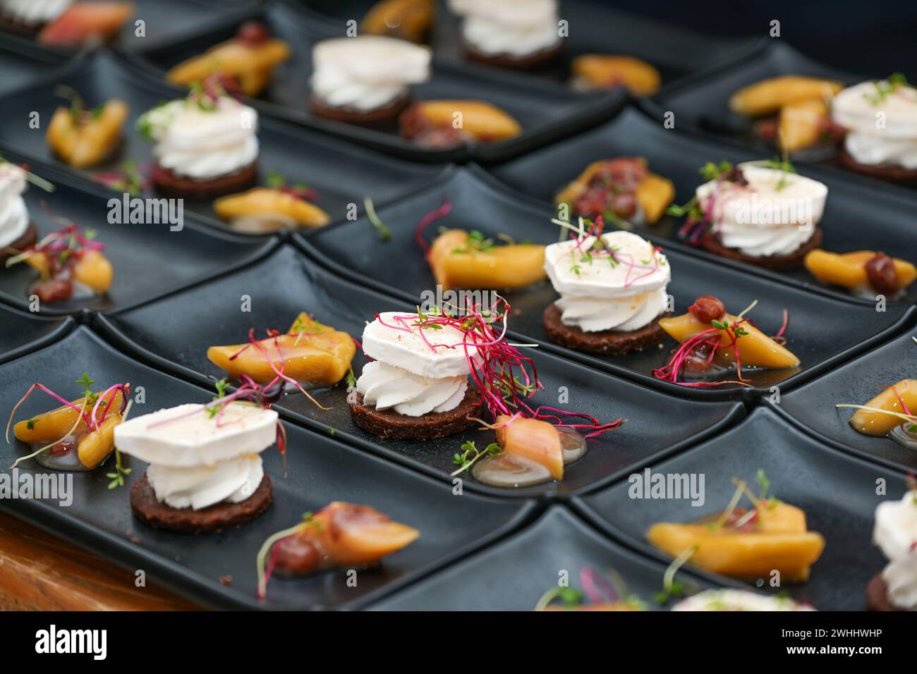 Many prepared appetizers of feta cheese and rhubarb with sprout garnish ...