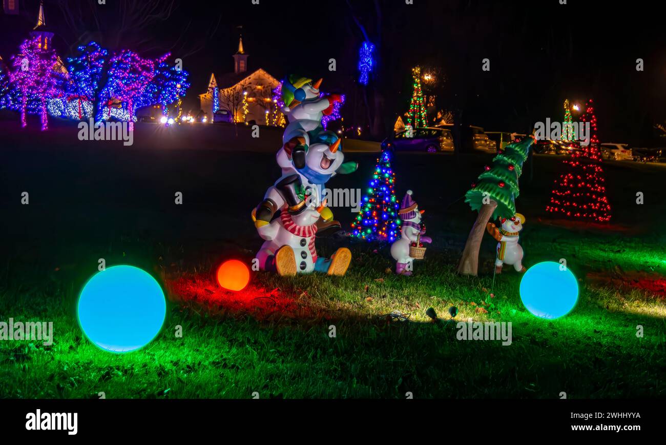 Nighttime Holiday Scene With Inflatable Snowman Figures And Brightly ...