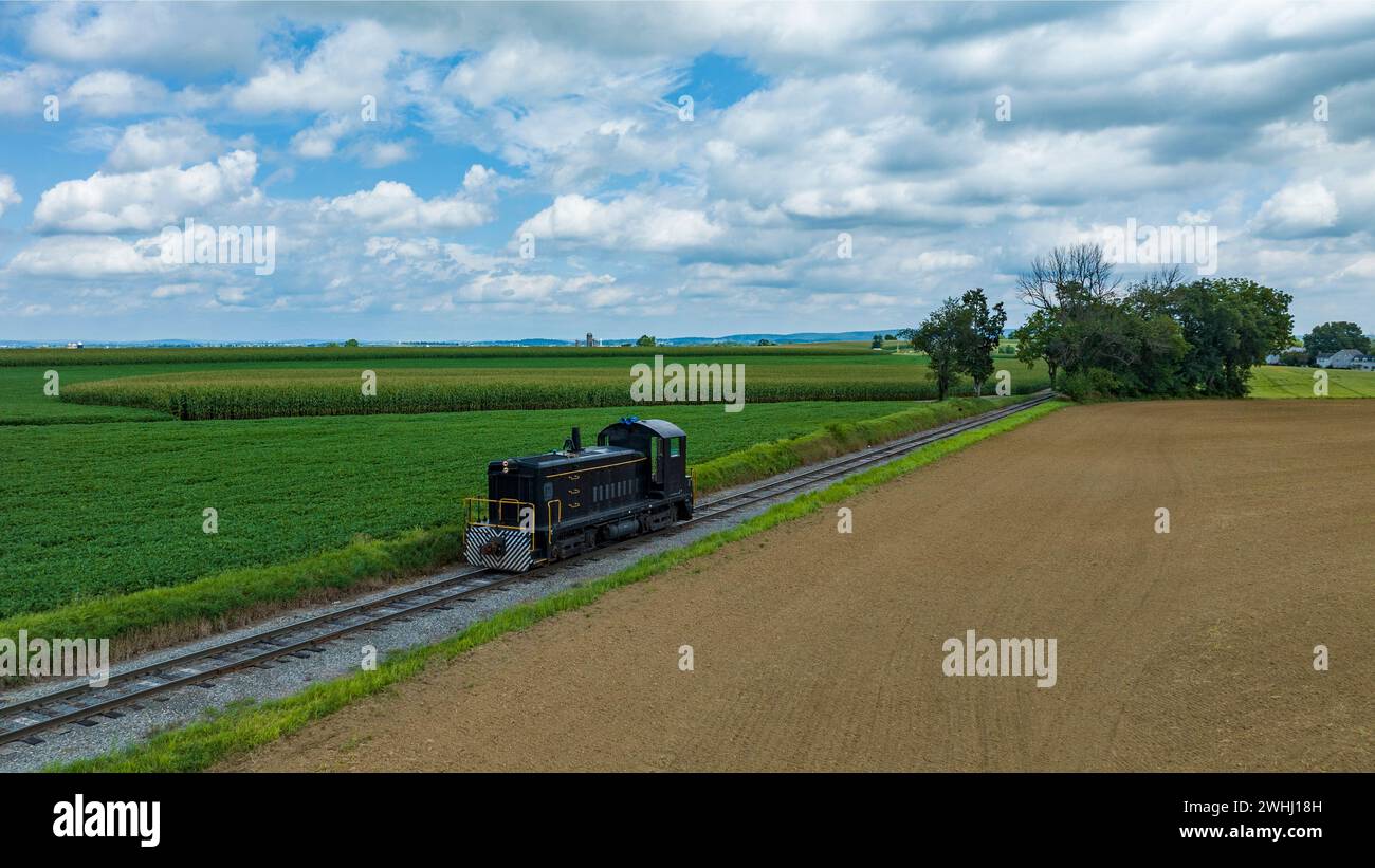 Single Locomotive Traversing Along Railway Tracks Bordering A Plowed ...