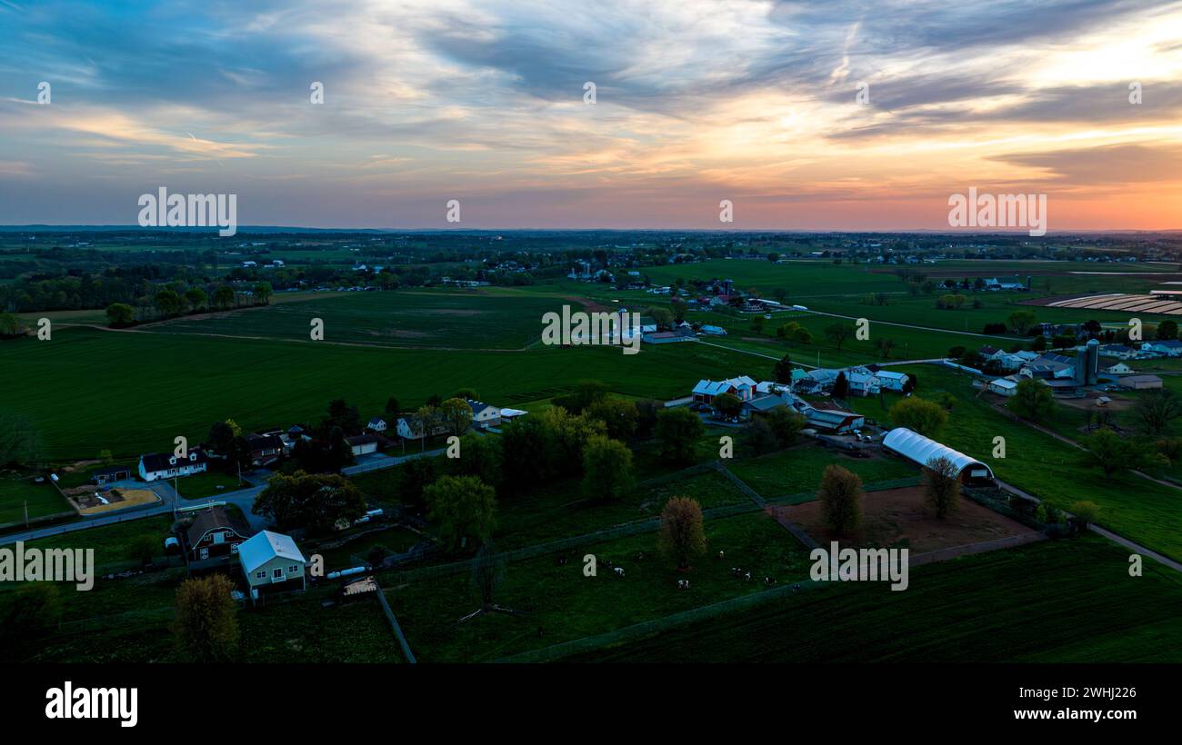 Sunset Casts A Warm Glow Over A Rural Farmland Tapestry With Homes ...