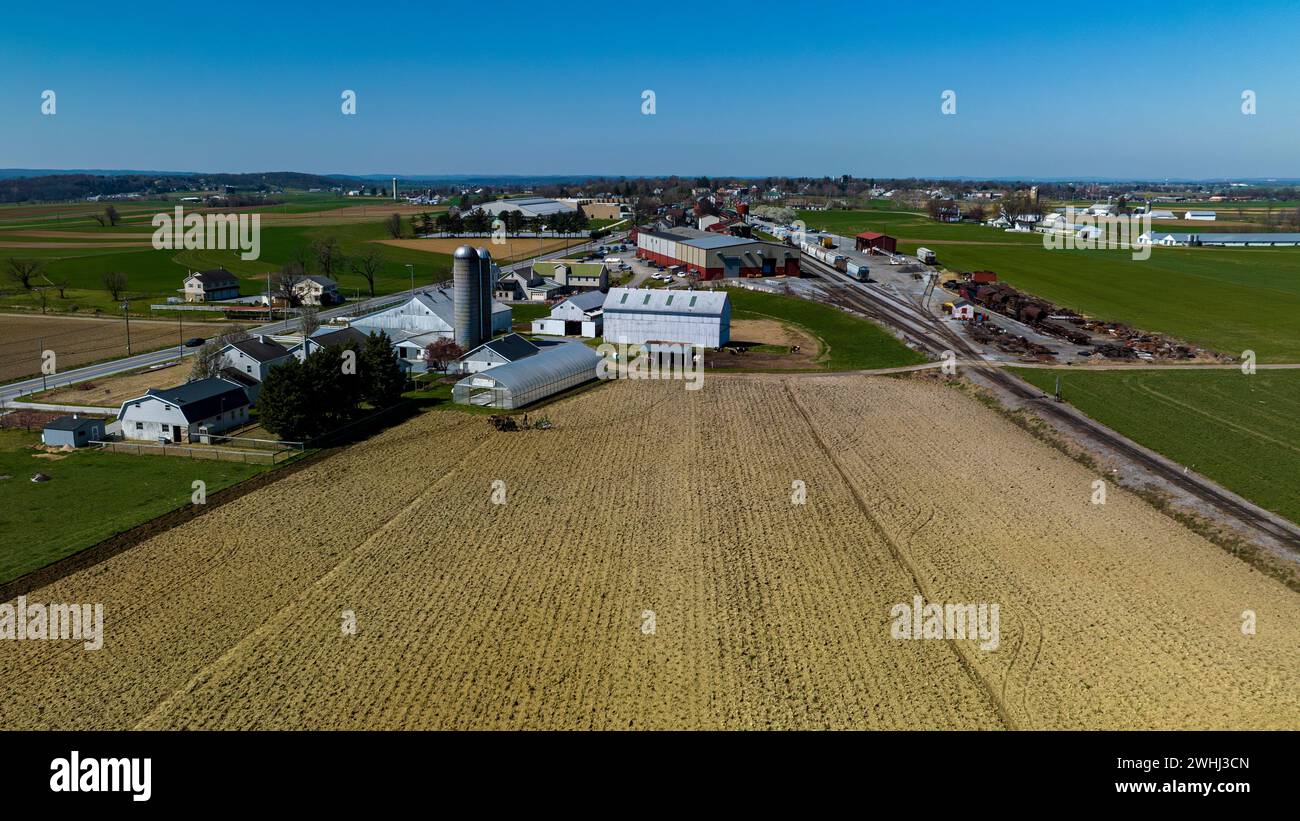 Aerial View Of A Farm Complex With Multiple Barns, Silos, And Plowed ...