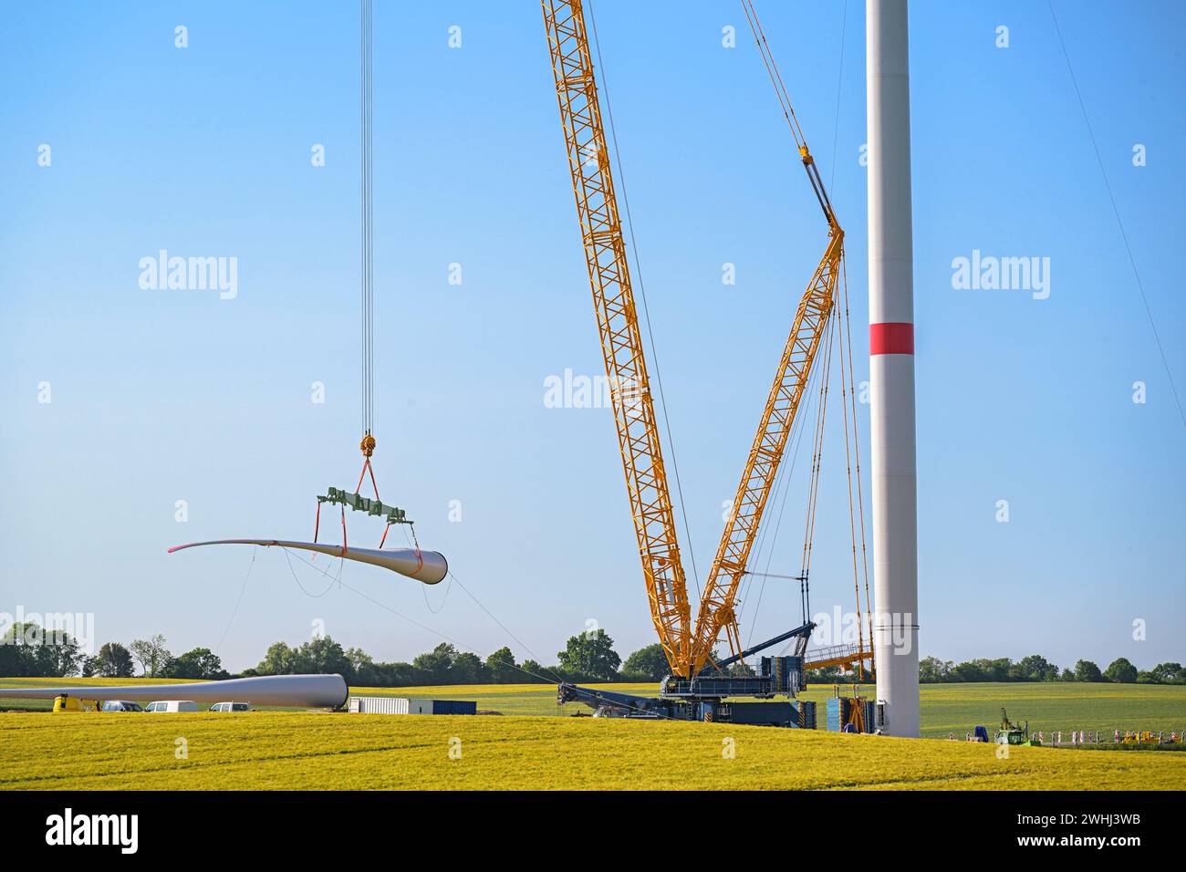 Giant crane lifting a wind turbine blade to install it onto the tower ...