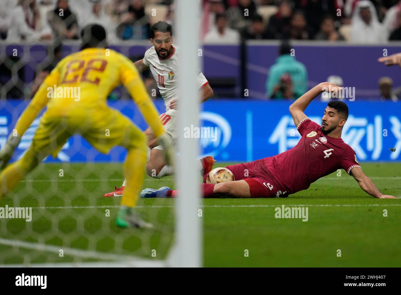 Jordan's Mousa Altamari, centre, has his shot blocked by Qatar's ...