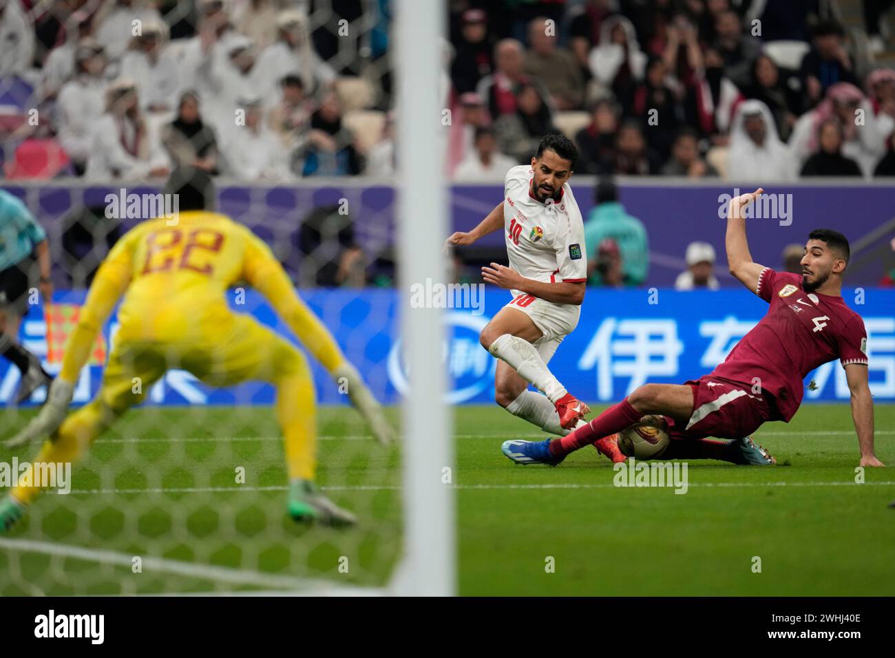Jordan's Mousa Altamari, centre, has his shot blocked by Qatar's ...