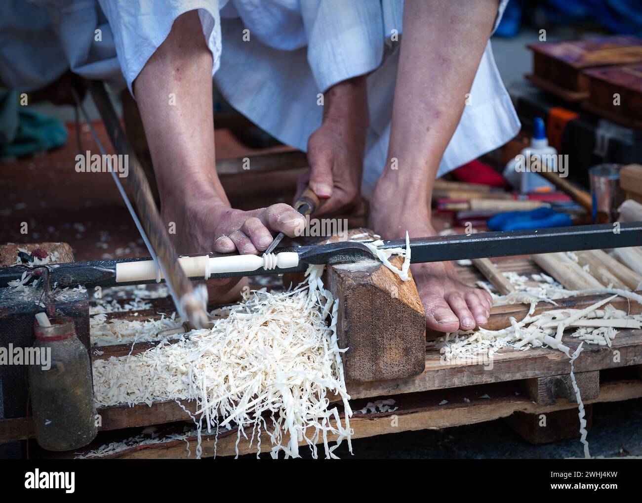 craftsman using his feet to carve wood Stock Photo - Alamy