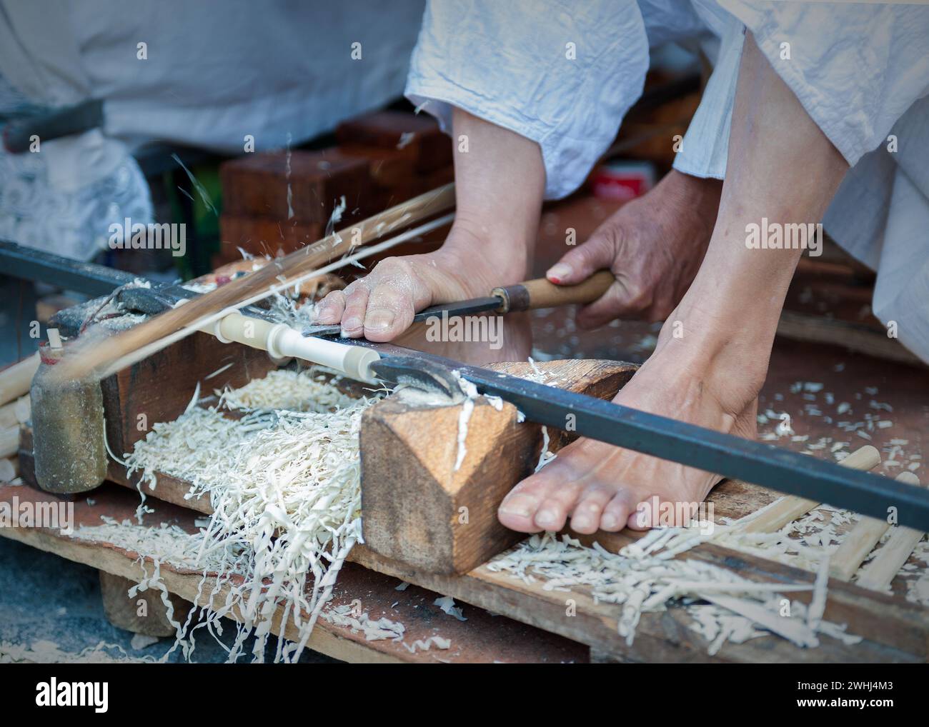 craftsman using his feet to carve wood Stock Photo - Alamy
