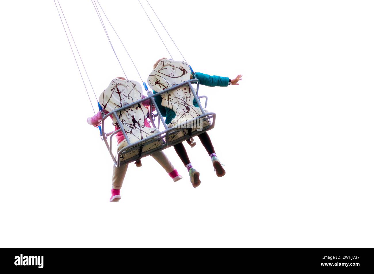 Children ride on a carousel in an amusement park isolated on white ...