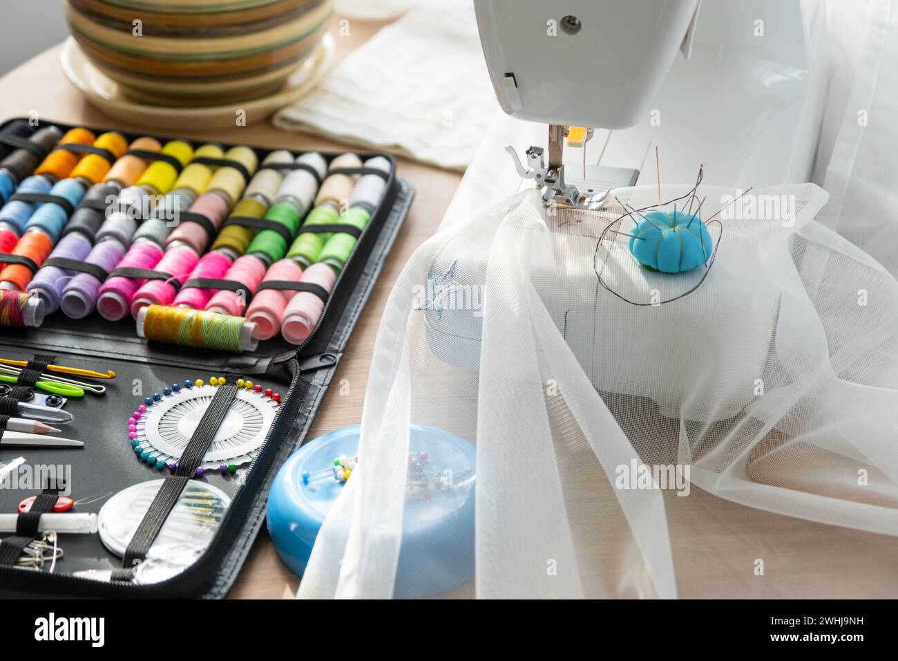 Sewing layout with multicolored spools of thread close-up, needles ...