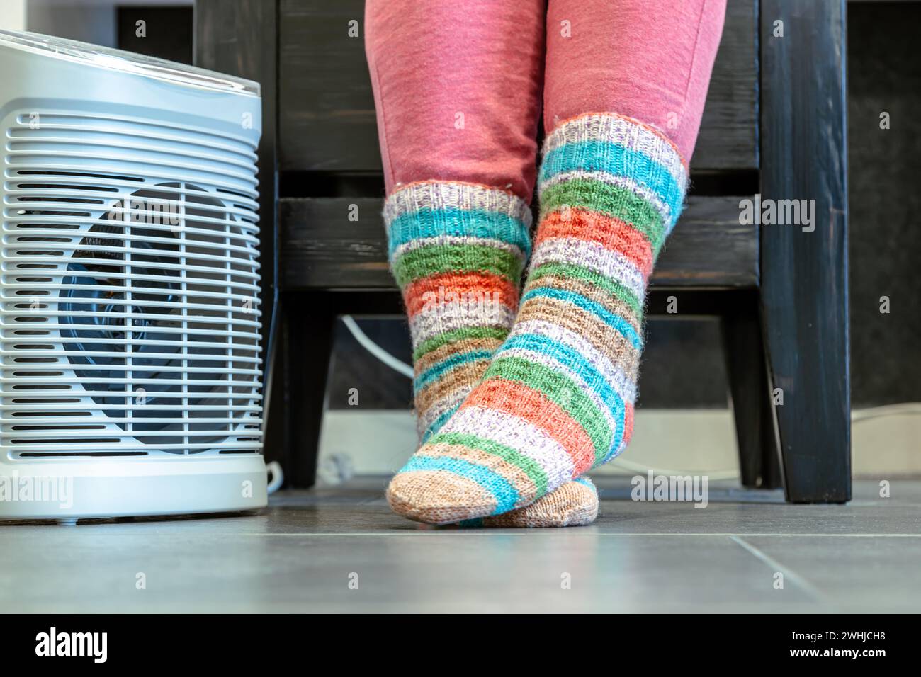 Heating season. feet in socks. woman feet with socks. Room heating with ...