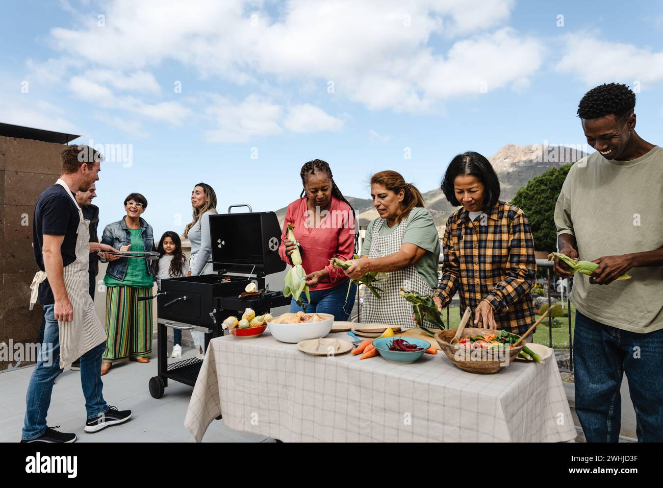 Multigenerational friends having fun doing barbecue at house rooftop ...