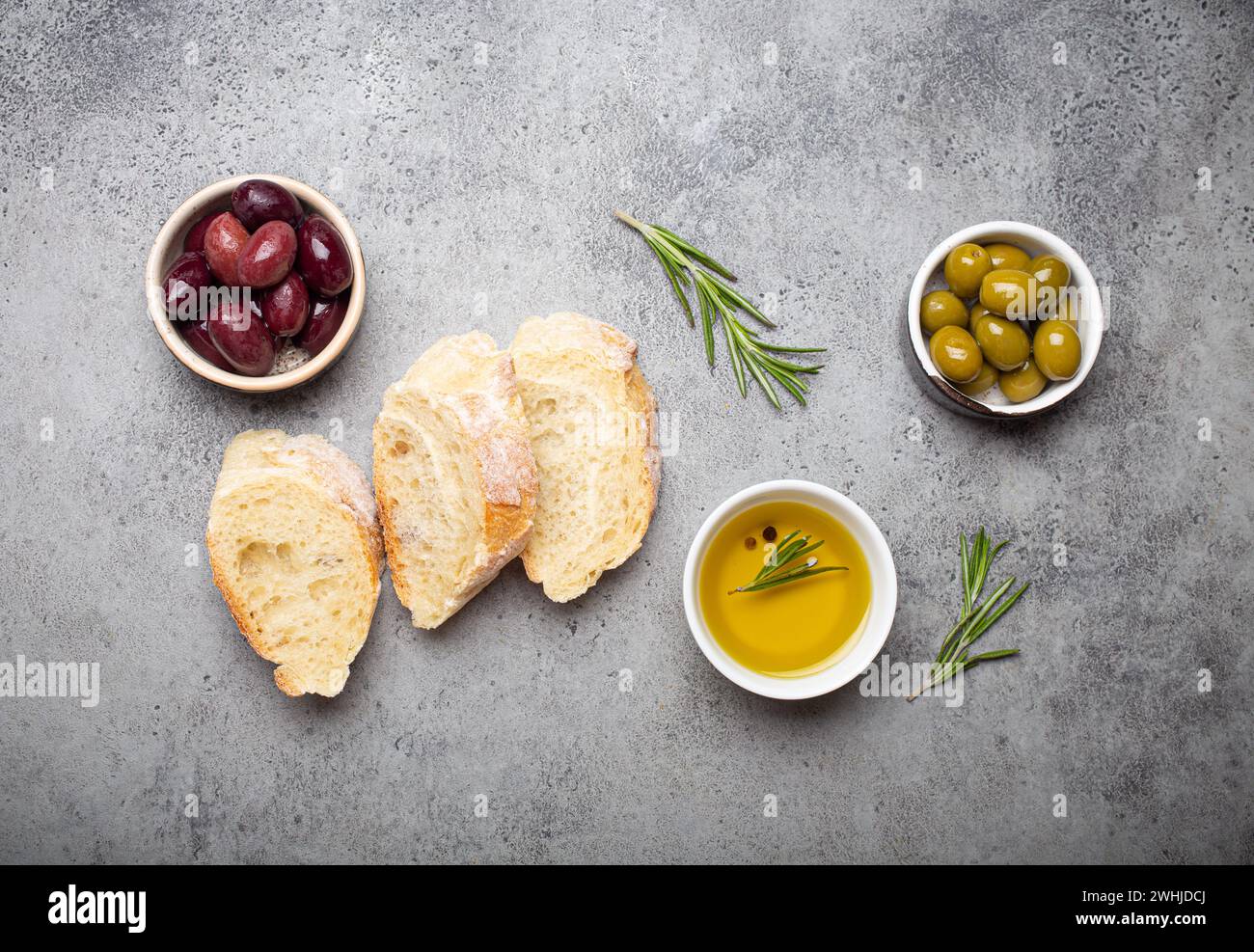 Slices of fresh ciabatta, green and brown olives, olive oil with ...