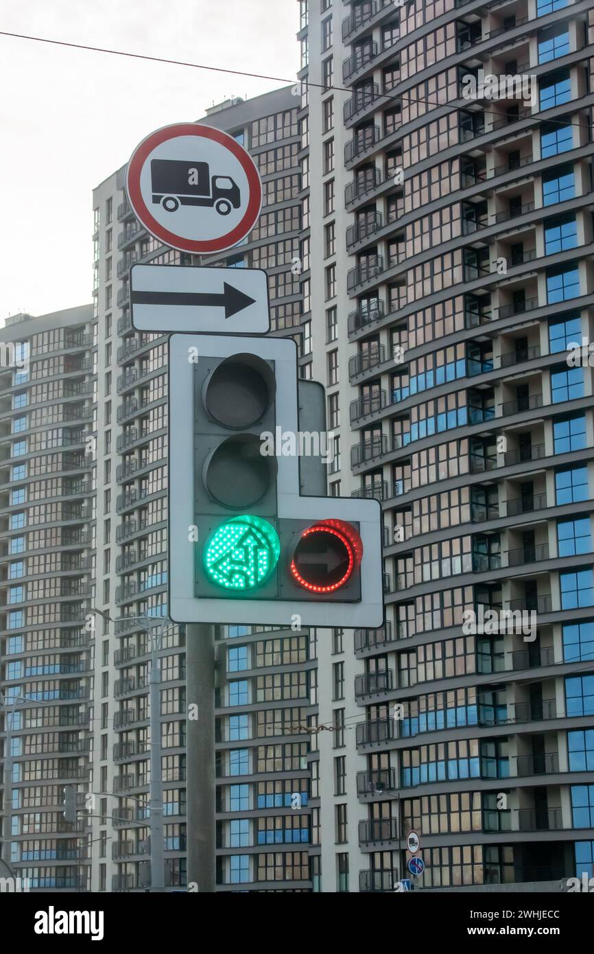 Green traffic light and road signs against tall building close up Stock ...