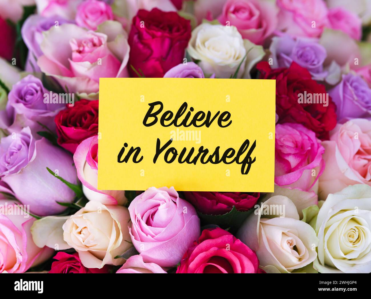 A yellow greeting card with words Believe in Yourself laying on a big ...