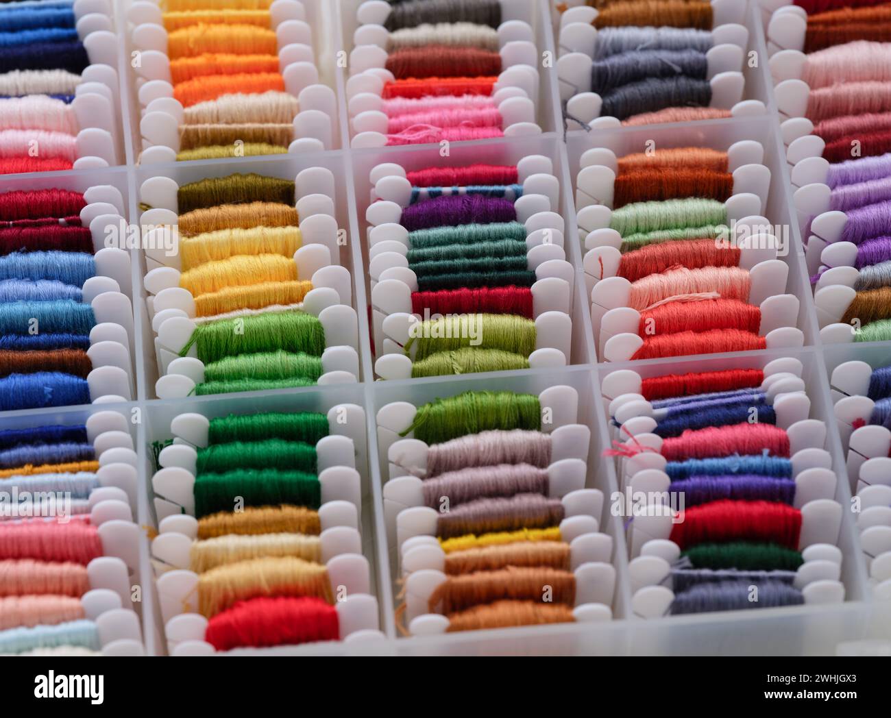 Plastic sorting box full of bobbins with different colour embroidery ...