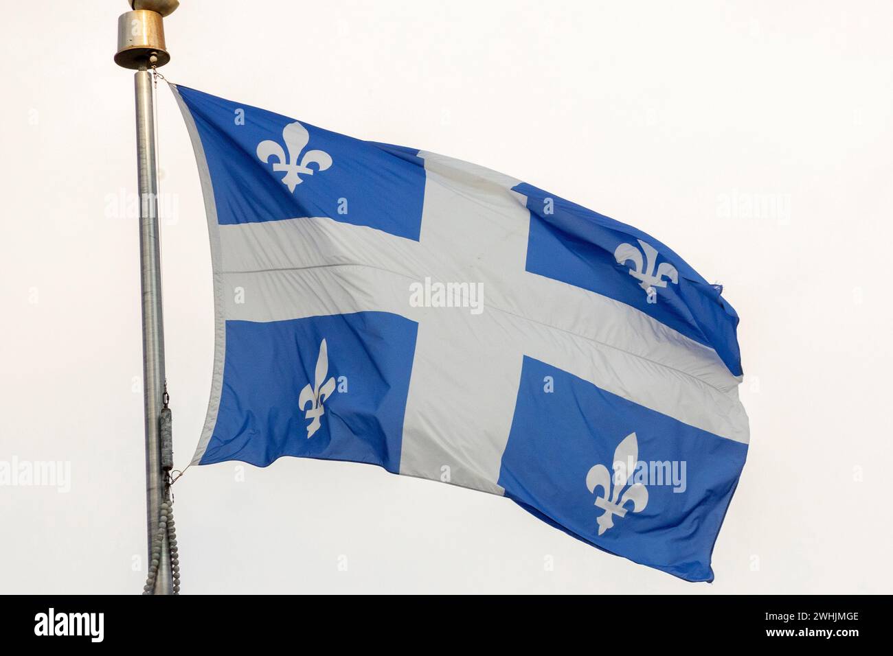 National flag of Quebec on a flagpole flutering on a wind Stock Photo ...