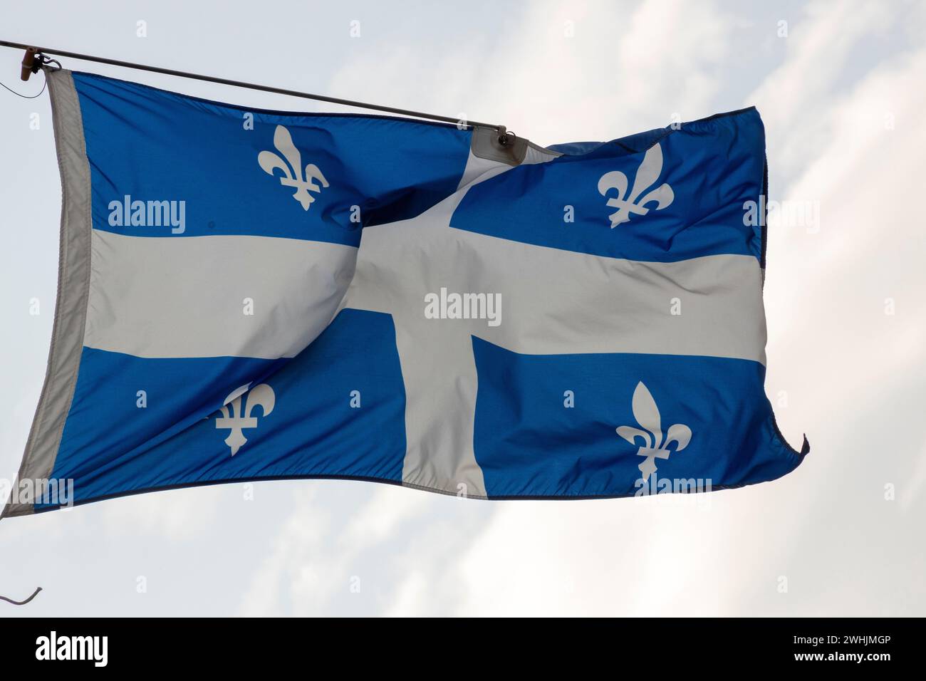 National flag of Quebec on a flagpole flutering on a wind Stock Photo ...