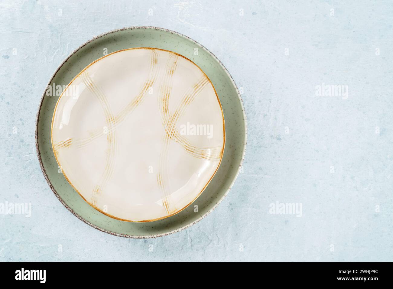 An empty plate with a gold rim, overhead flat lay shot on a slate ...