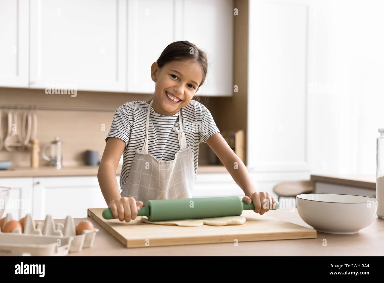 Happy baker kid girl in household apron preparing bakery meal Stock ...