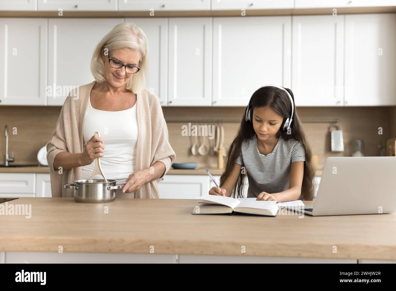 Focused pre teen schoolkid girl doing homework task at home Stock Photo ...