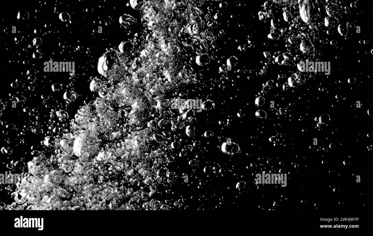 Soda water bubbles splashing underwater against black background. Soda liquid texture that ...