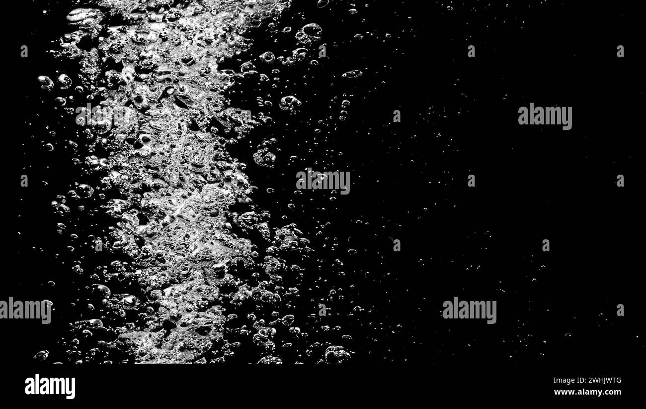 Soda water bubbles splashing underwater against black background. Soda liquid texture that ...