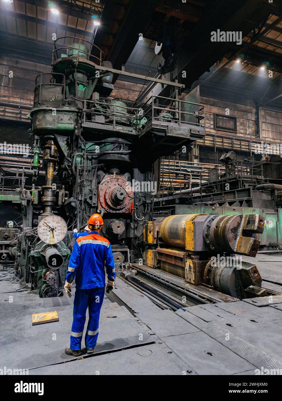 Rolled metal factory. Continuous hot rolling mill and factory worker ...