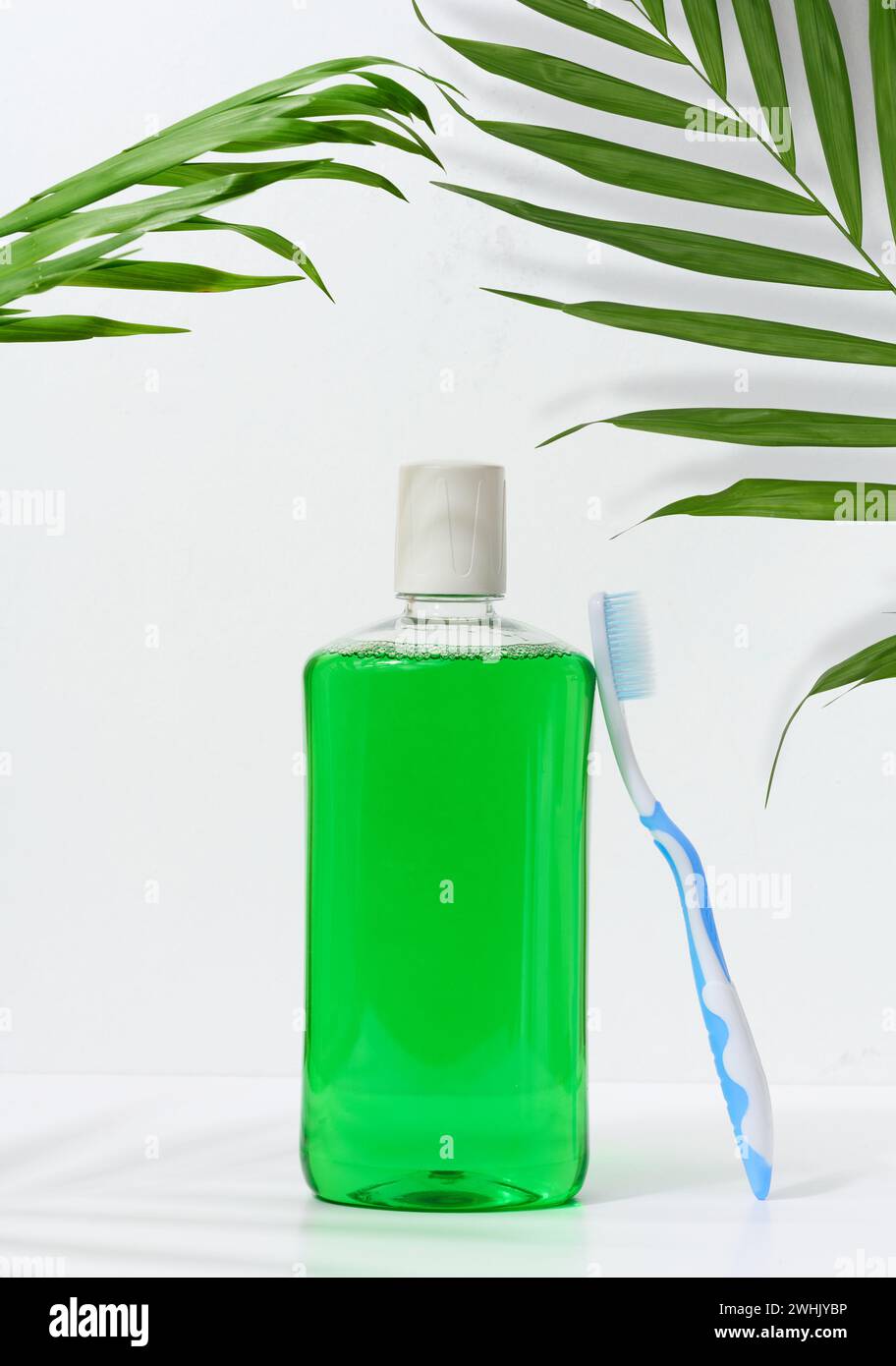 Refreshing mouthwash in a transparent plastic bottle and a toothbrush ...